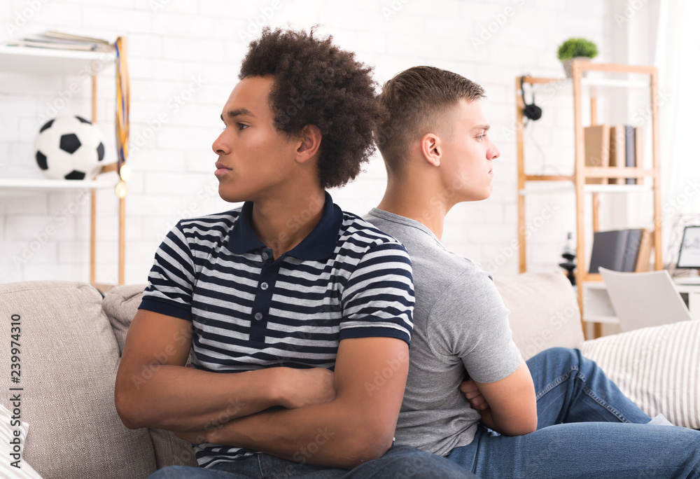 Two angry roommates sitting back to each other Stock Photo | Adobe Stock