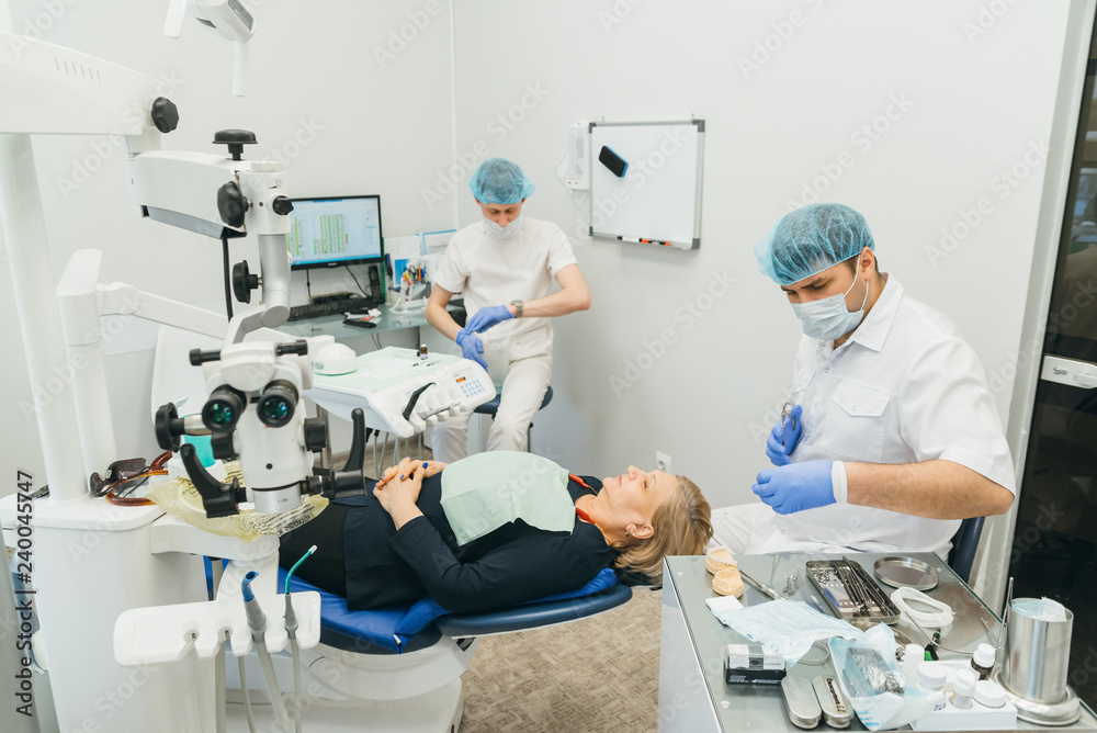 Doctor used microscope. Dentist is treating patient in modern dental ...