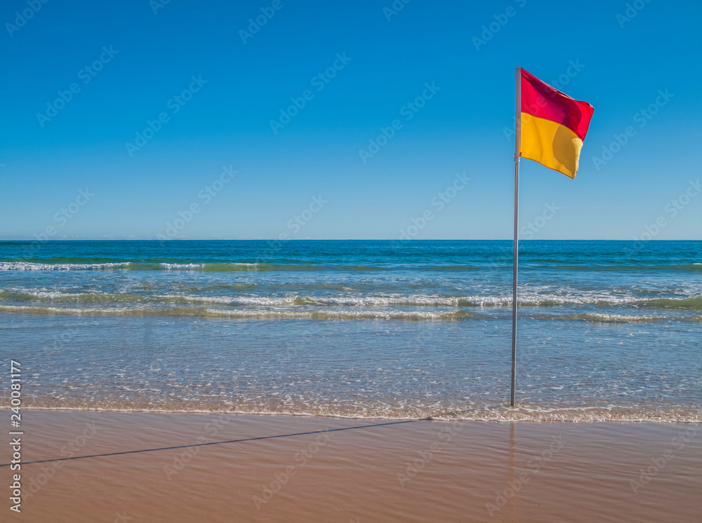 Beach with red and yellow flag indicating safe, patrolled beach in ...
