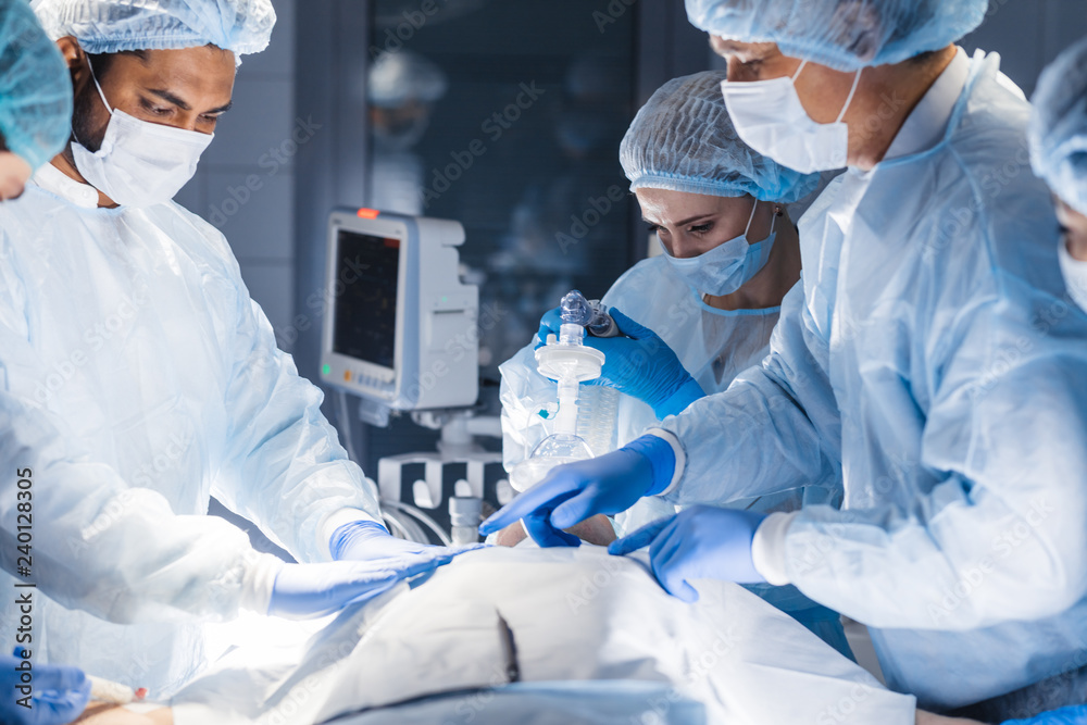 Foto de Team of experienced doctors and assistants performing difficult ...
