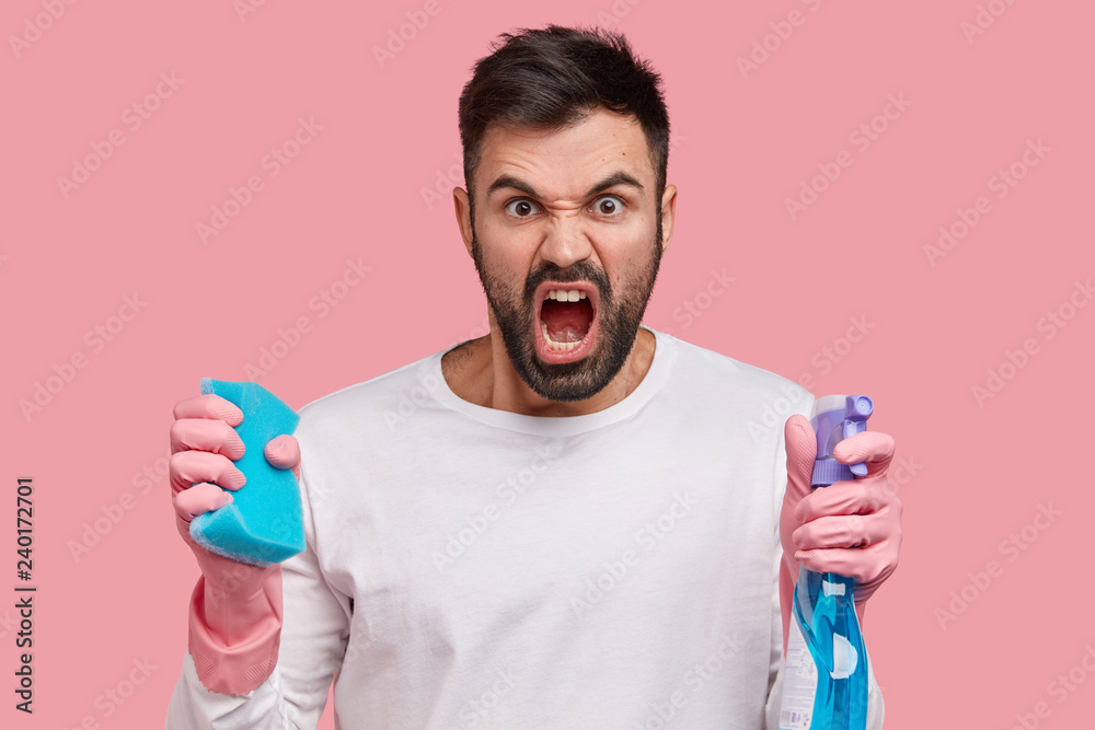 Outraged unshaven man carries blue mop and detergent, dressed in white ...