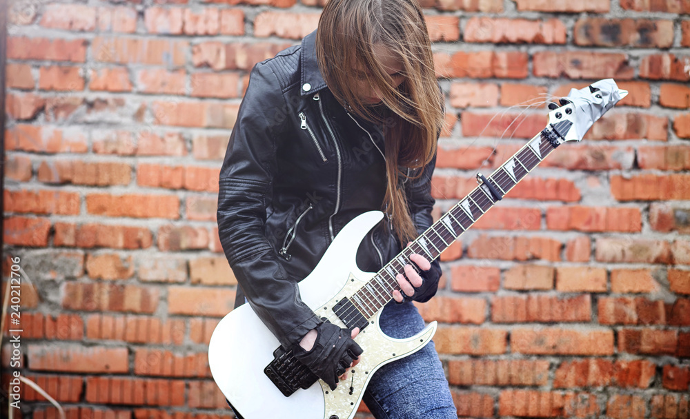 Beautiful young girl rocker with electric guitar. A rock musician girl ...