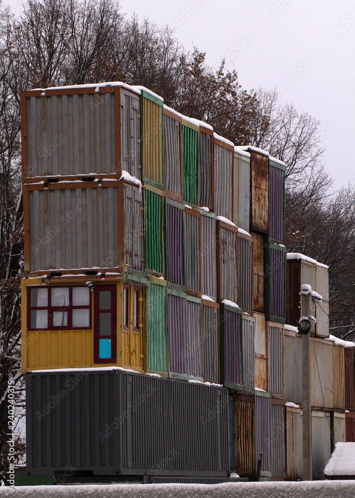 Four vertical rows of shipping containers that are different colors ...