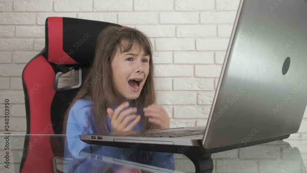 Shock child at the computer. Fear on the Internet. The little girl is ...