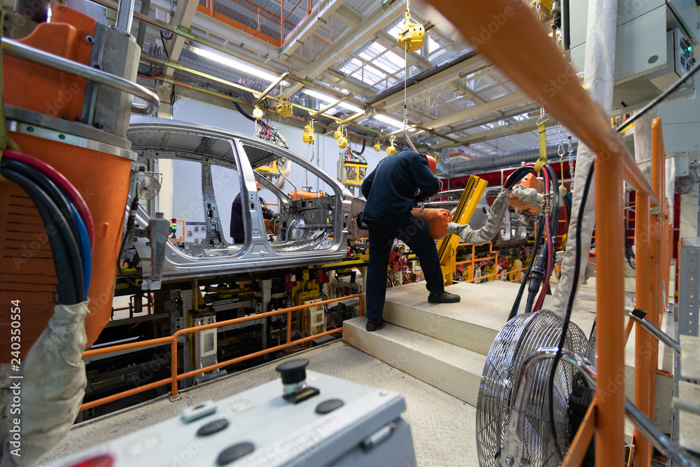 Workers assemble a vehicle body. process of welding cars. Modern ...