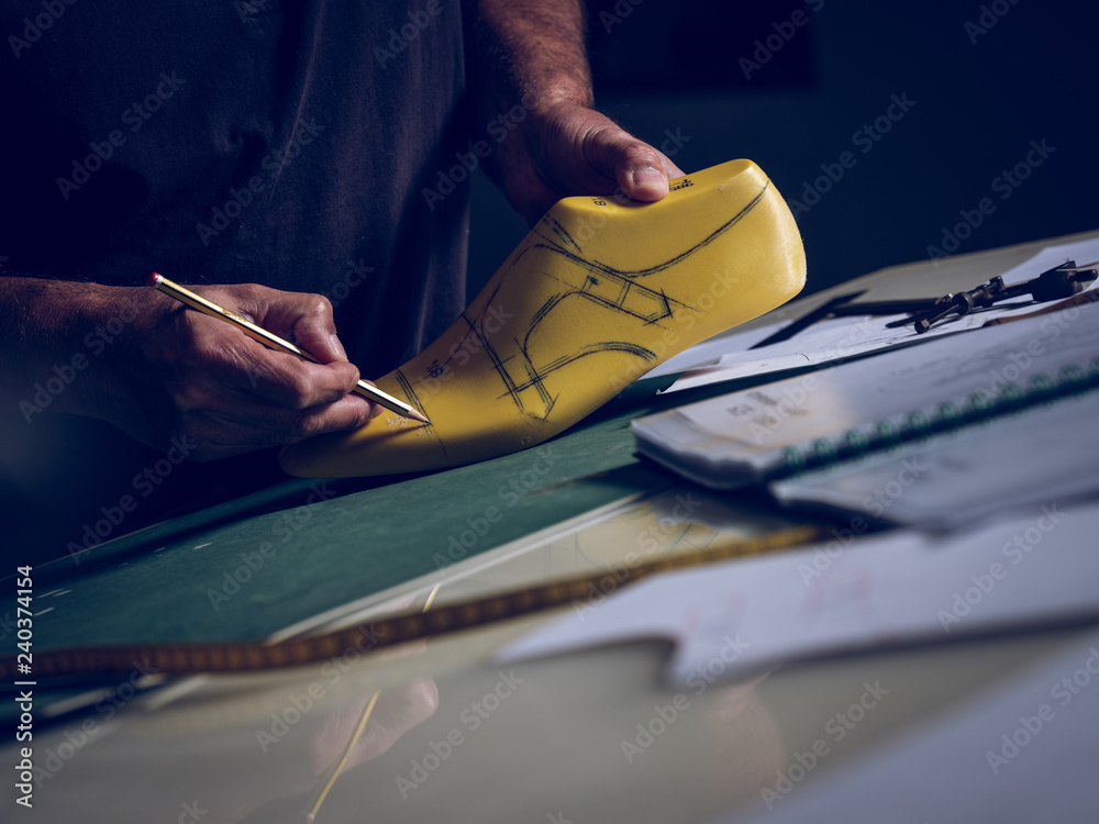 Crop shoemaker making marks on last Stock Photo | Adobe Stock