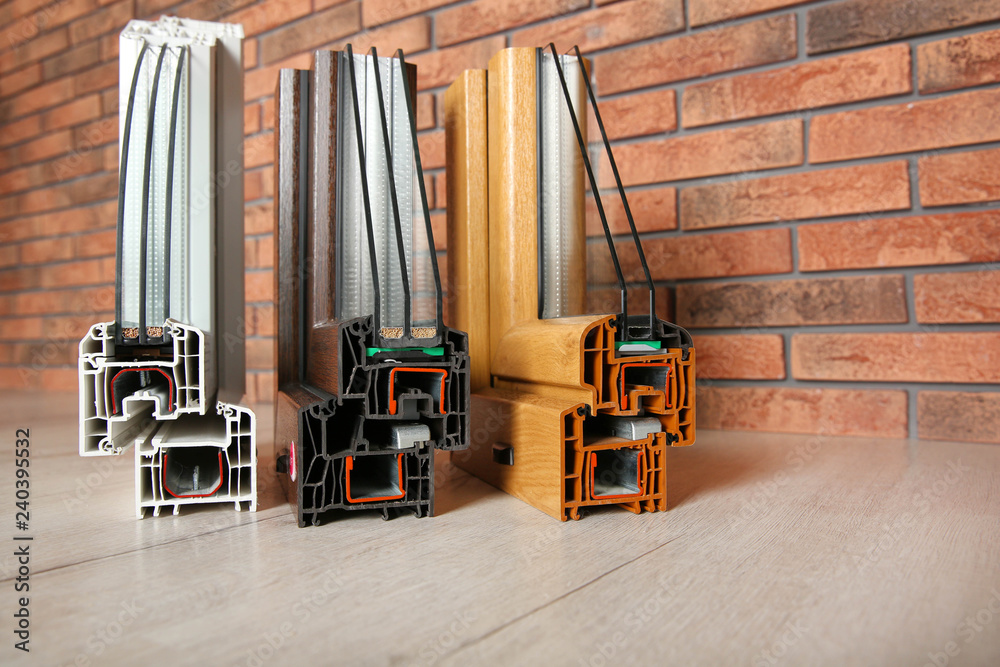 Samples of modern window profiles on floor against brick wall ...