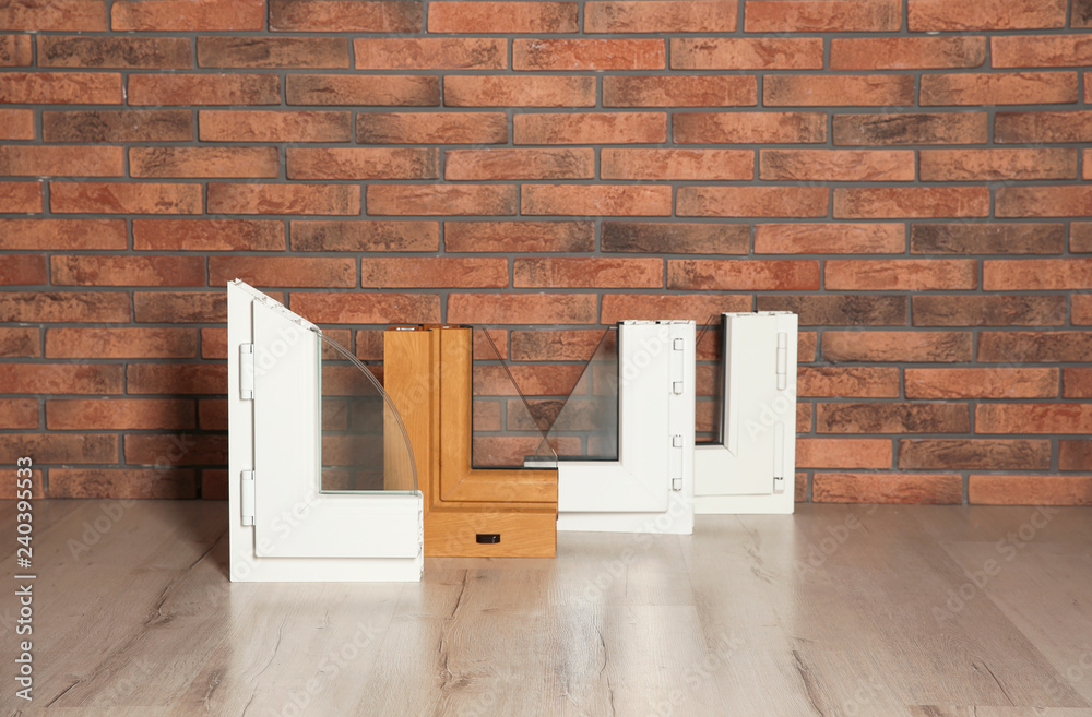Samples of modern window profiles on floor against brick wall ...
