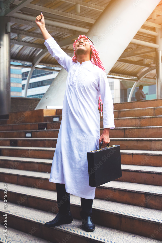 Muslim Arab man.He is raise hand and holding business Bag.He is smile ...