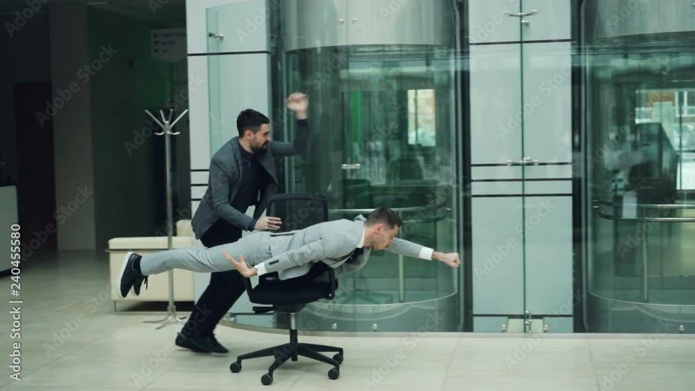 Bearded guys businessmen are having great time at office party riding ...