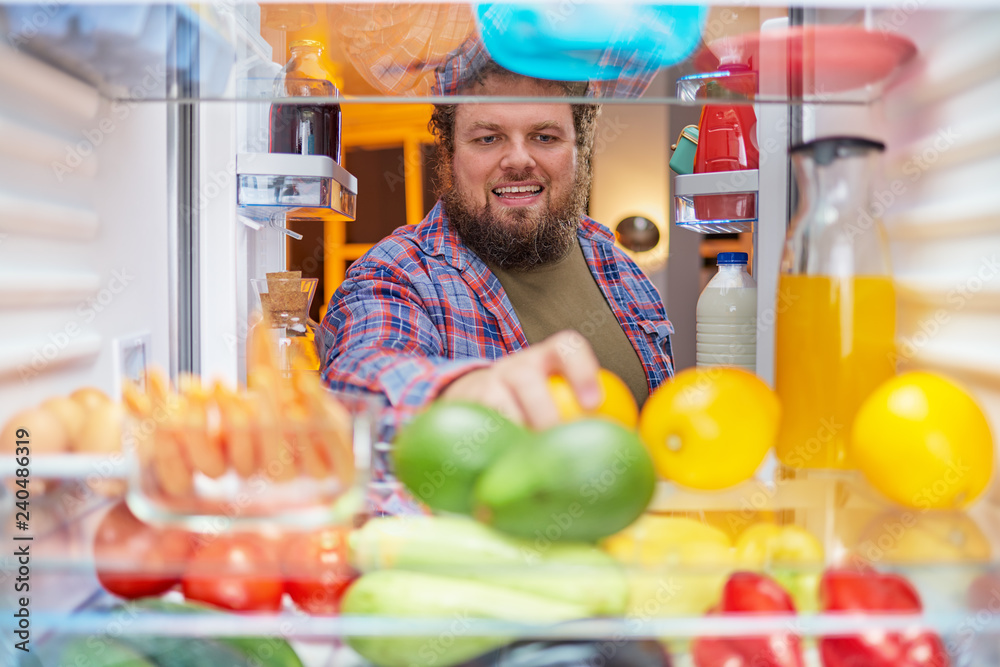 Man looking for something to eat at night while standing in front of ...