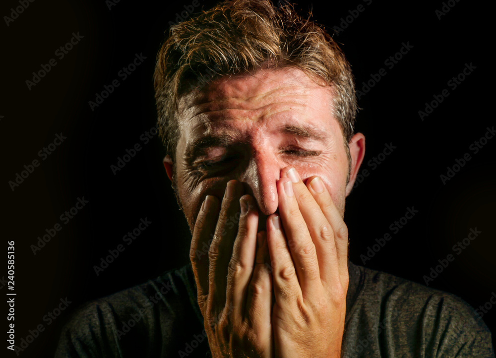 young sad and devastated man crying desperate covering face with his ...