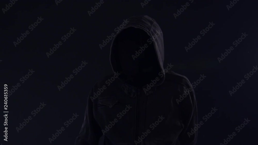 Hooded computer hacker click virtual screen, low key slow motion ...
