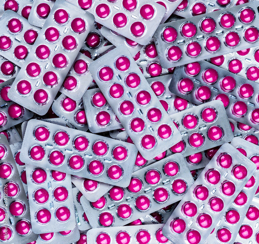 Pile of round pink tablets pill in blister pack. Pharmaceutical ...