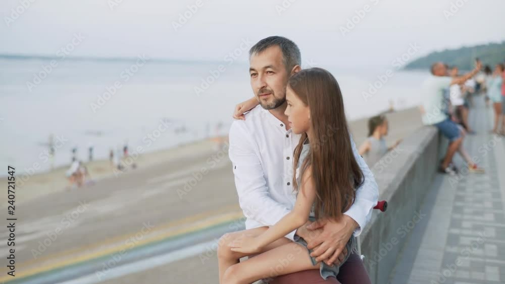 Vidéo Stock A girl sits on her father's lap. A man and his daughter are ...
