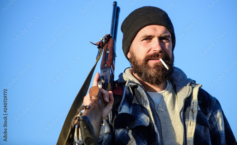 Man brutal bearded guy gamekeeper blue sky background. Brutality and ...