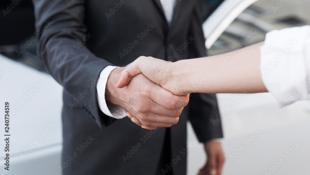 Female salesman shaking hands with customer in dealership Stock Photo ...