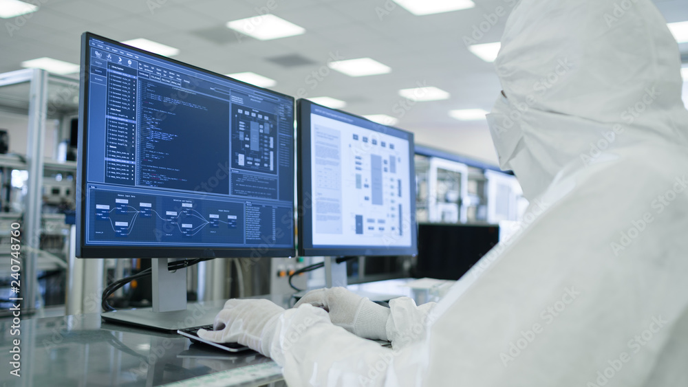 Shot of a Scientists in Sterile Suits Working with Computers, Analyzing ...