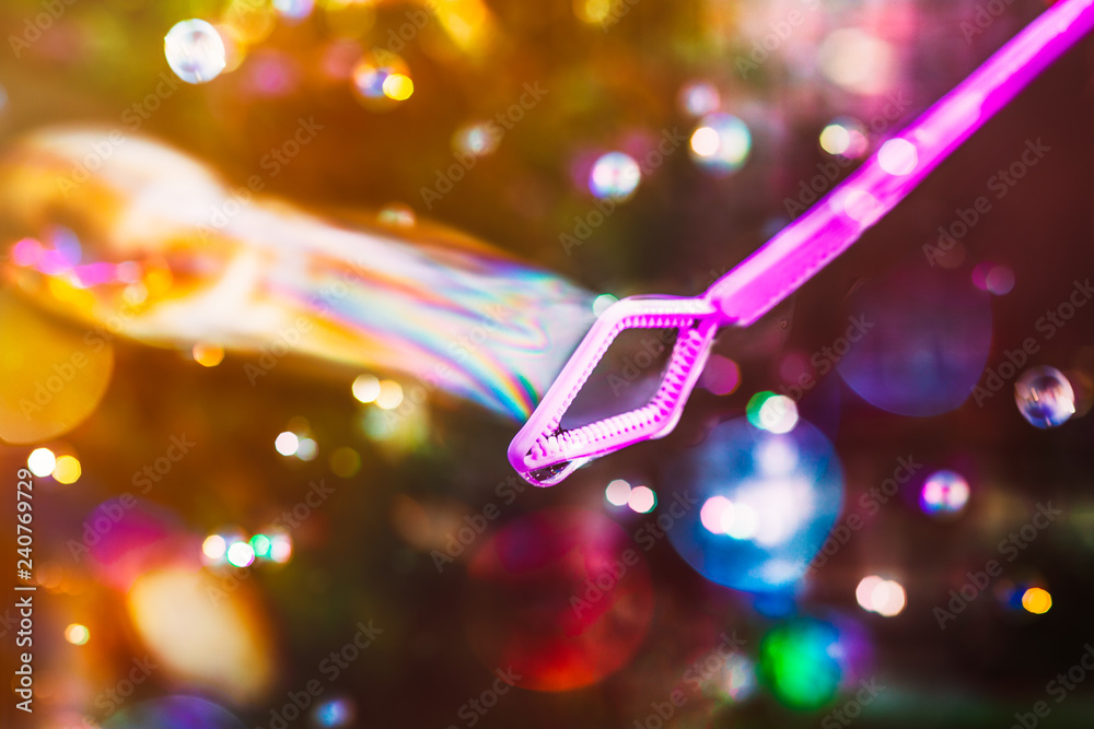 Pink bubble wand being pulled through the air creating a stream of ...