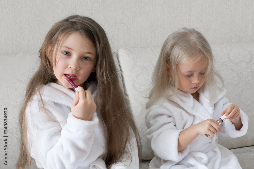 Girlfriends of girls paint lips with lipstick. Two little girls in ...