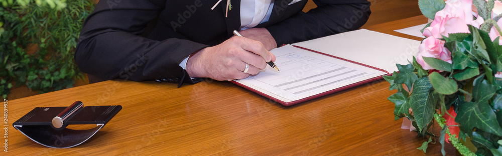 Man with Pen Signet a certificate on the Desk Stock Photo | Adobe Stock