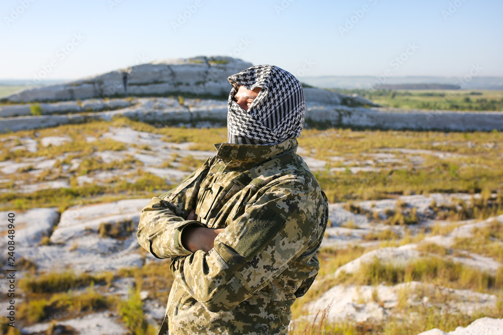 Soldier is standing in the camouflage uniform and checkered keffiyeh ...