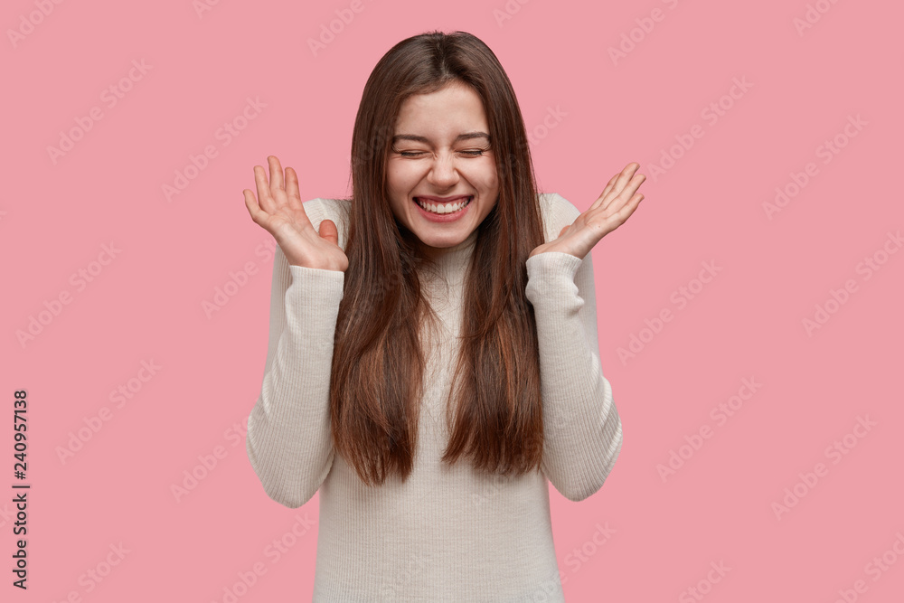Overjoyed smiling lady spreads palms, expresses joy and happiness, asks ...