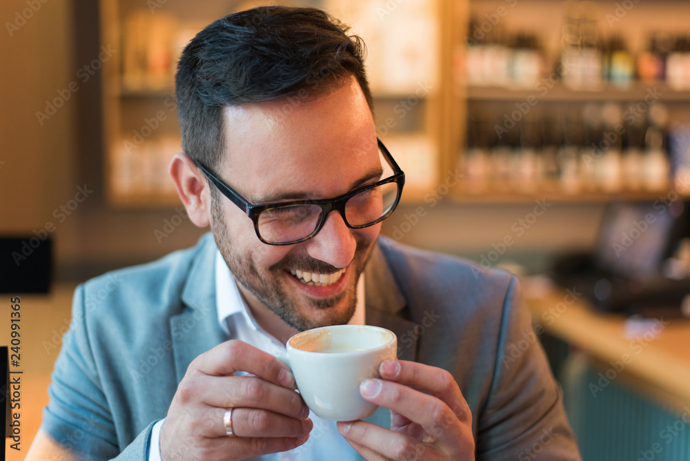 Attractive beautiful smiling businessman drinking coffee at restaurant ...