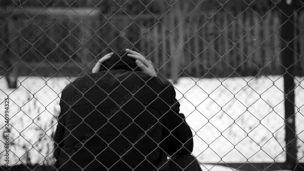 Young unidentifiable teenage boy holding hes head at the correctional ...