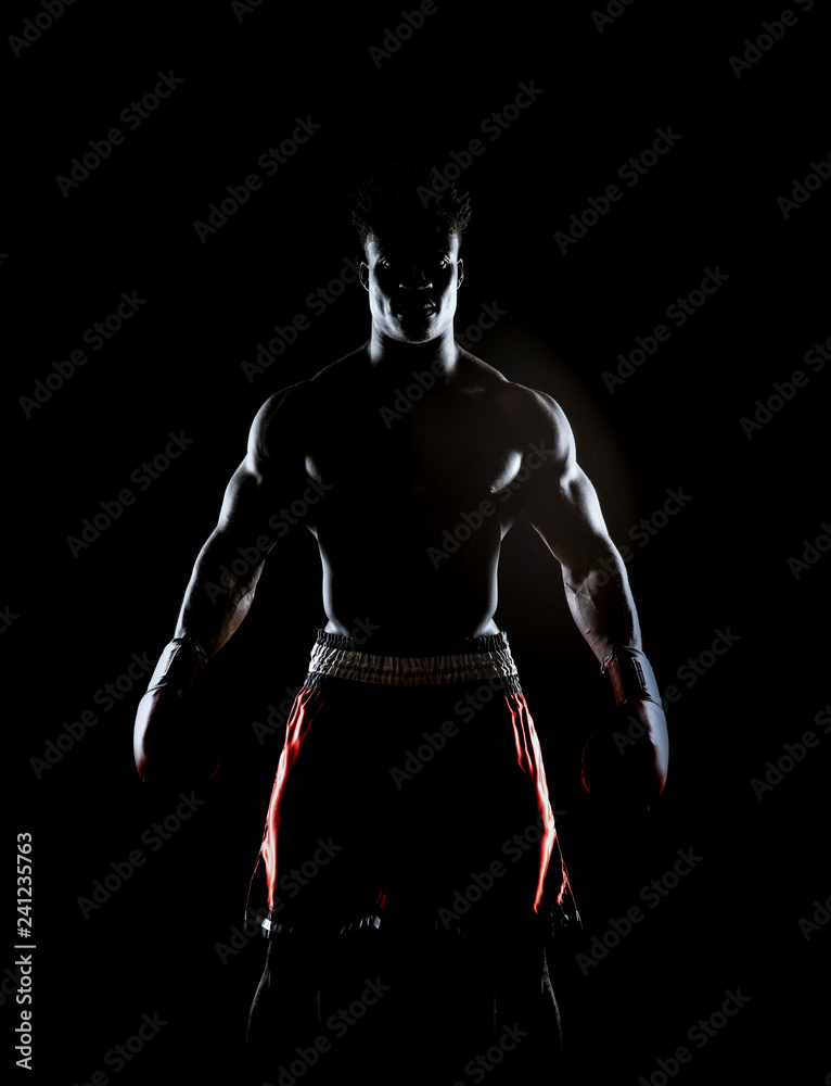 Silhouette of a muscular African American Black male boxer stands ...