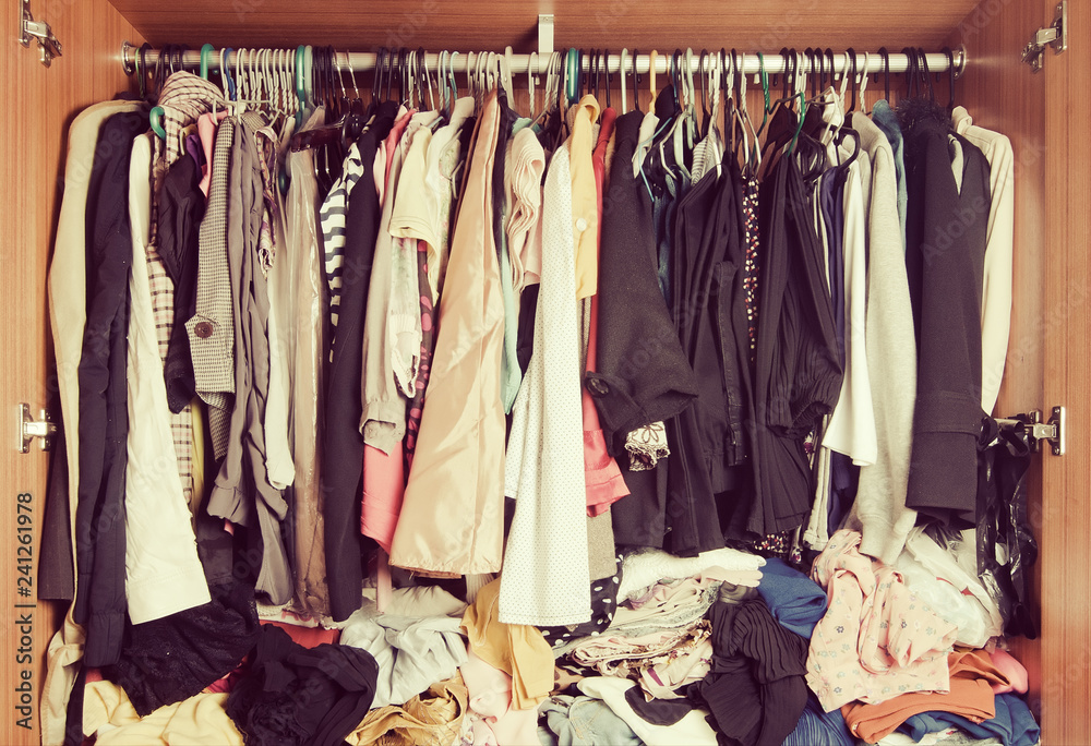 Pile of messy clothes in closet. Untidy cluttered woman wardrobe in ...