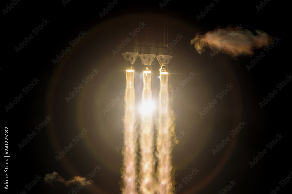 Missile launch at night. Dark sky with clouds, and lens flare at the ...