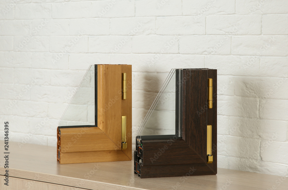Samples of modern window profiles on table against brick wall ...