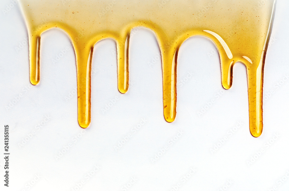 Dripping golden sweet honey flowing down the frame from the top over ...