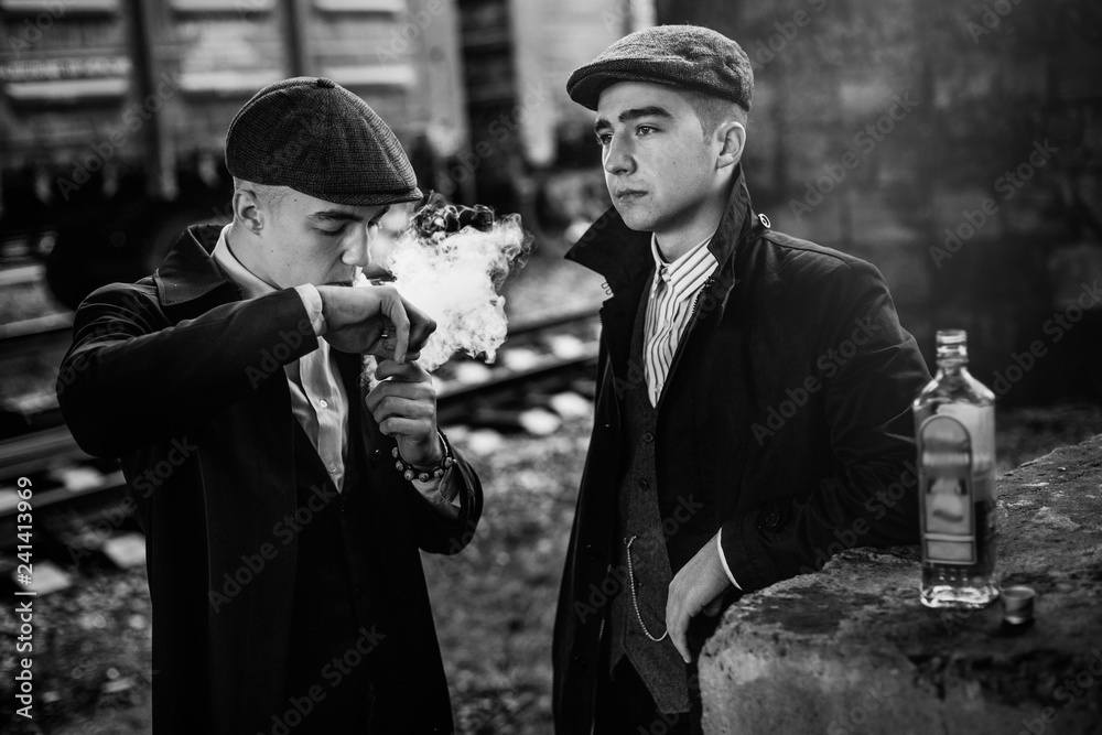 stylish gangsters smoking in tweed outfit posing on background of ...