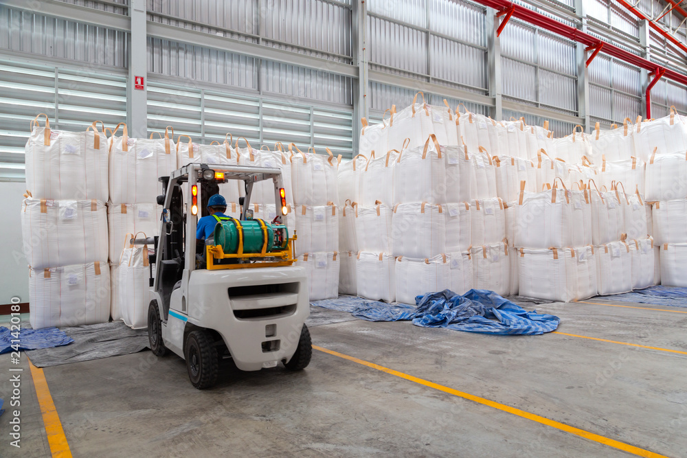 Forklift is handling jumbo bags in large warehouse for distribution to ...