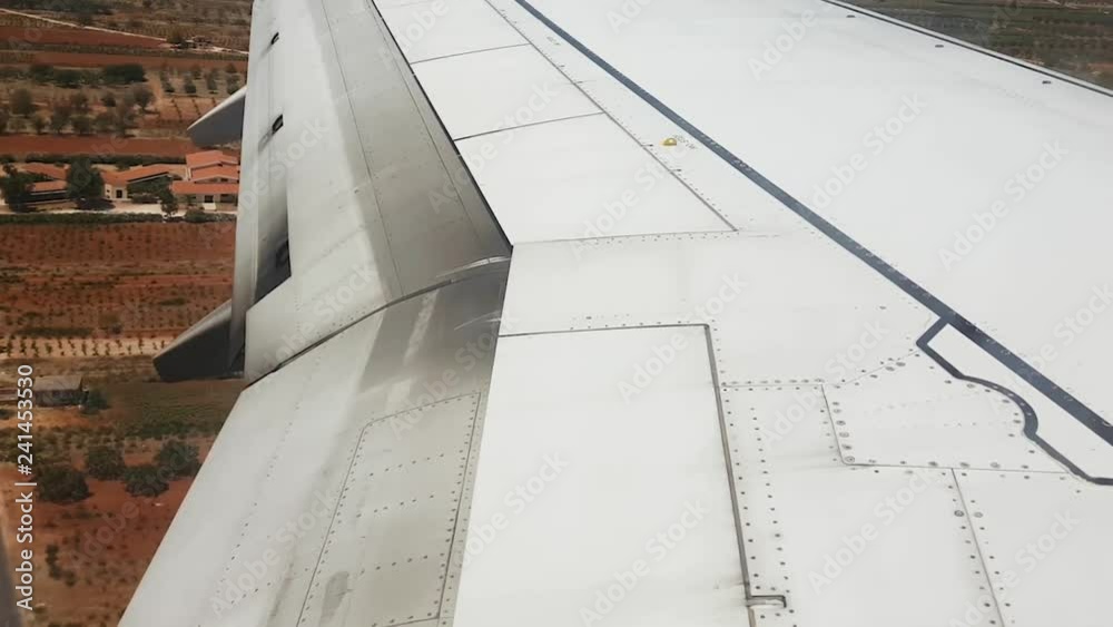 Wing view of aircraft flaps moving during windy landing. Athens ...
