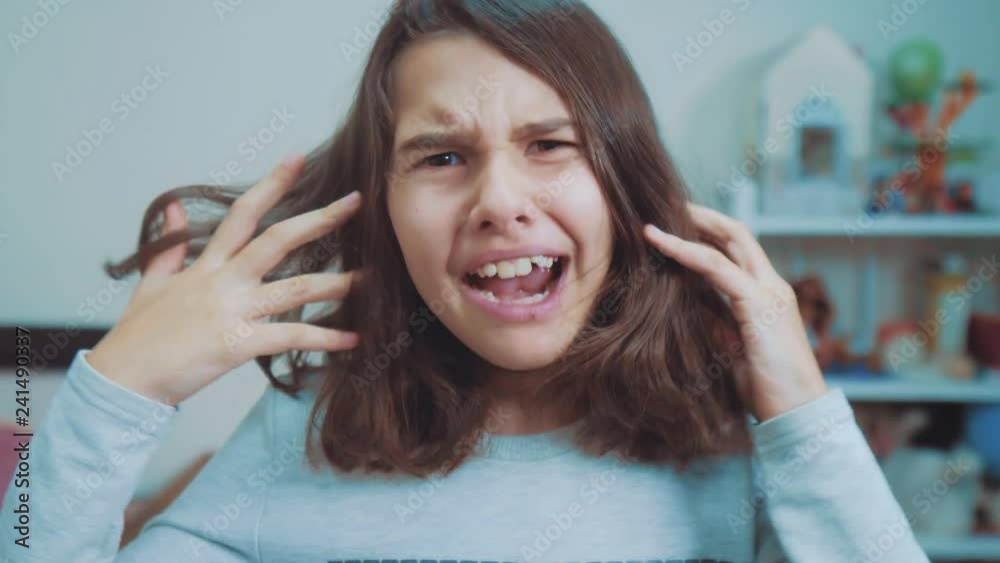 schoolgirl covering her face with her hands. emotion depression concept ...