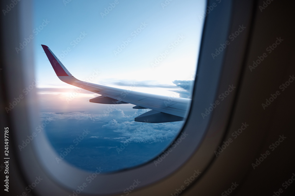 Clouds and sky with sunset as seen through window of an aircraft ...