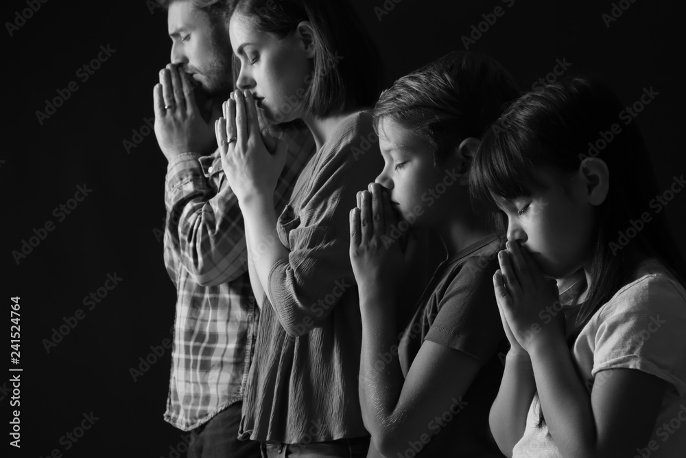 Praying family on dark background Stock Photo | Adobe Stock