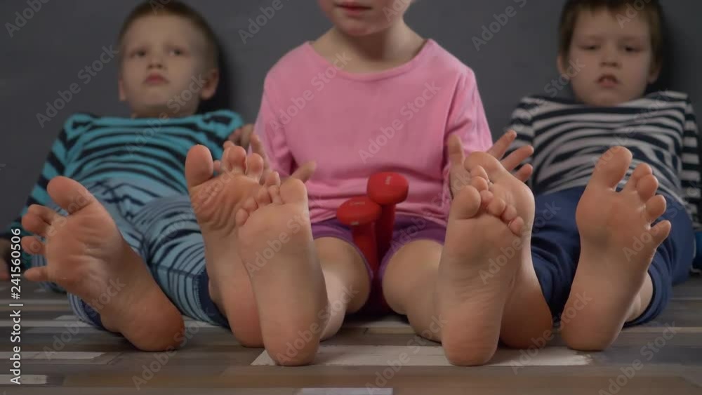 Cheerful children in multi-colored striped clothes are engaged in ...
