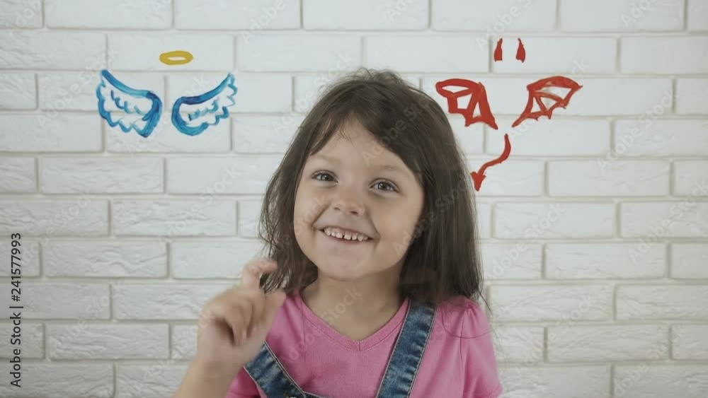 Angel and the devil. Good and evil. Evil or kind child. A cute little ...