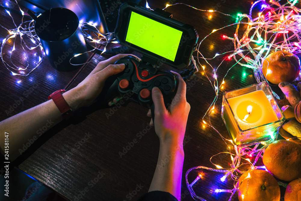 Game Pad with smartphone in girl hands, on black background with ...