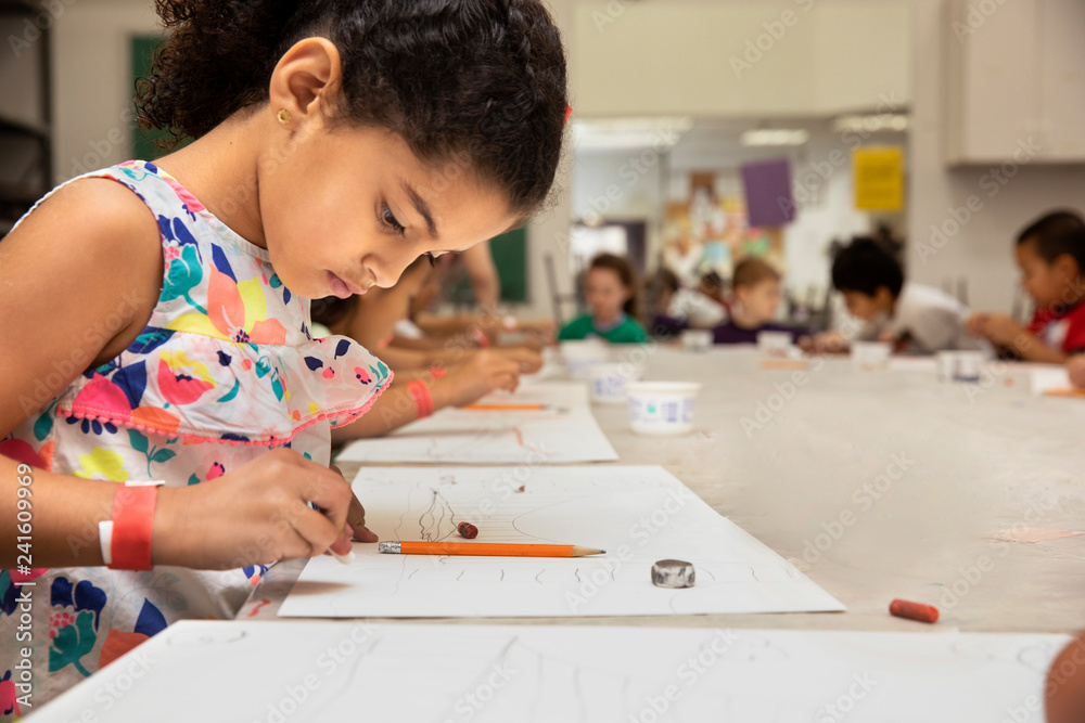 Young girl drawing in a classroom Stock Photo | Adobe Stock