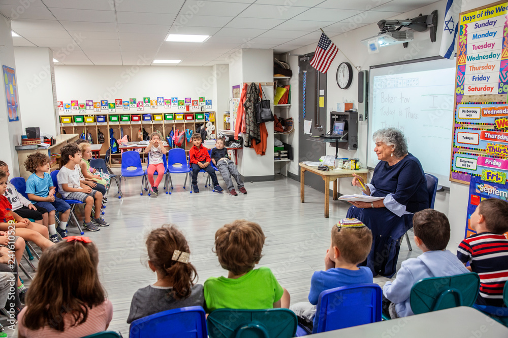 Teacher teaching a classroom full of children Stock Photo | Adobe Stock
