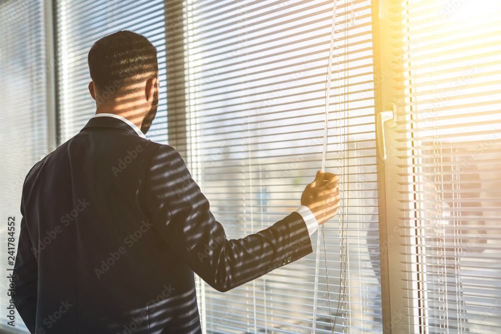 The man standing near the office window with jalousie Stock Photo ...