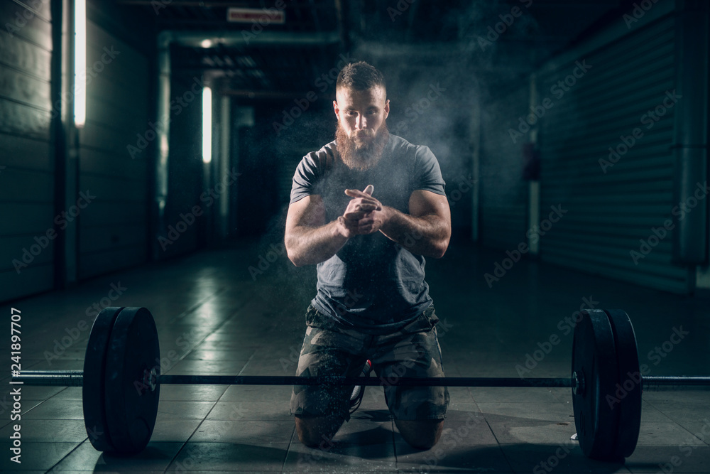 Muscular attractive caucasian bearded man in corridor kneeling ...