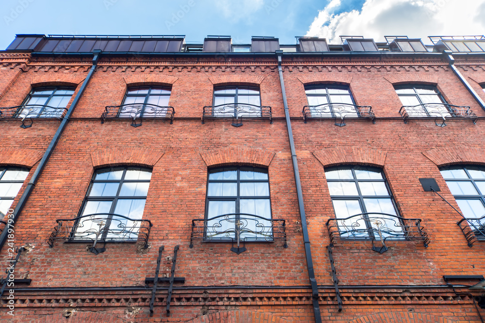 Huge red brick classic industrial building facade with multiple windows ...