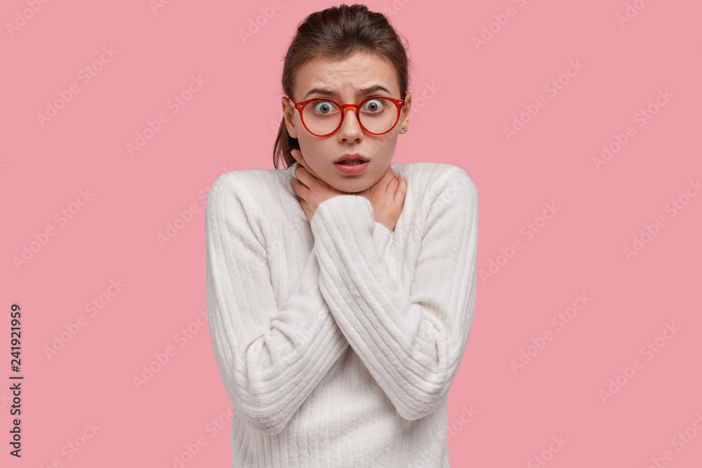 Scared Caucasian woman holds hands on neck while chocks from fright ...