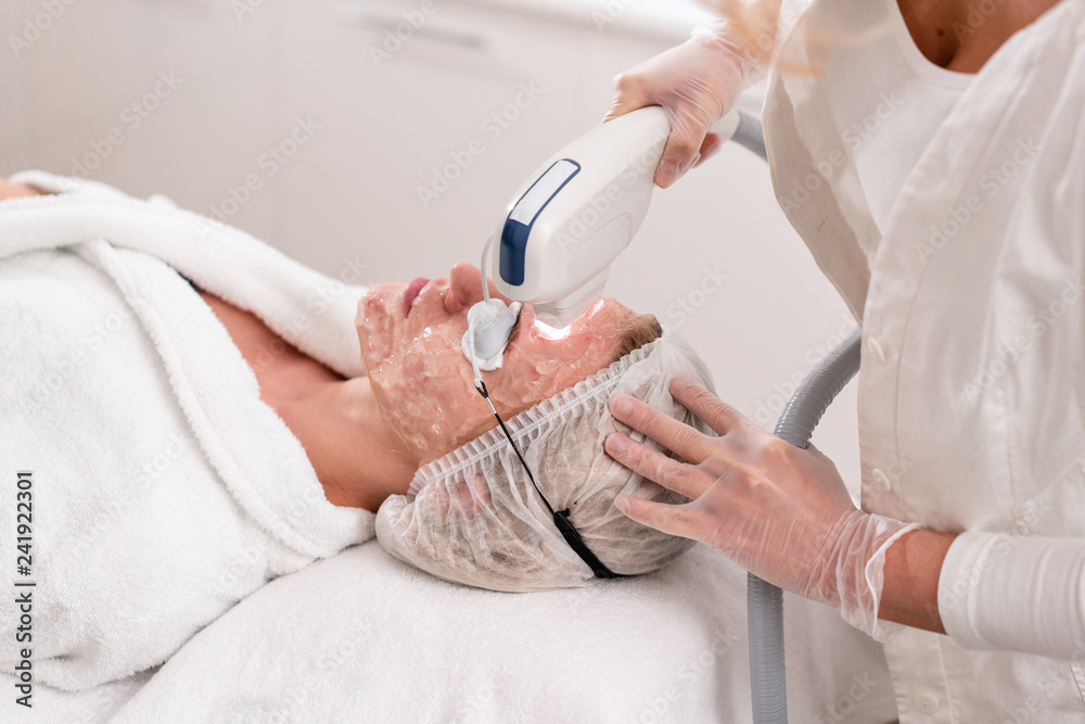Anti acne phototherapy with professional equipment. Beautiful woman in ...